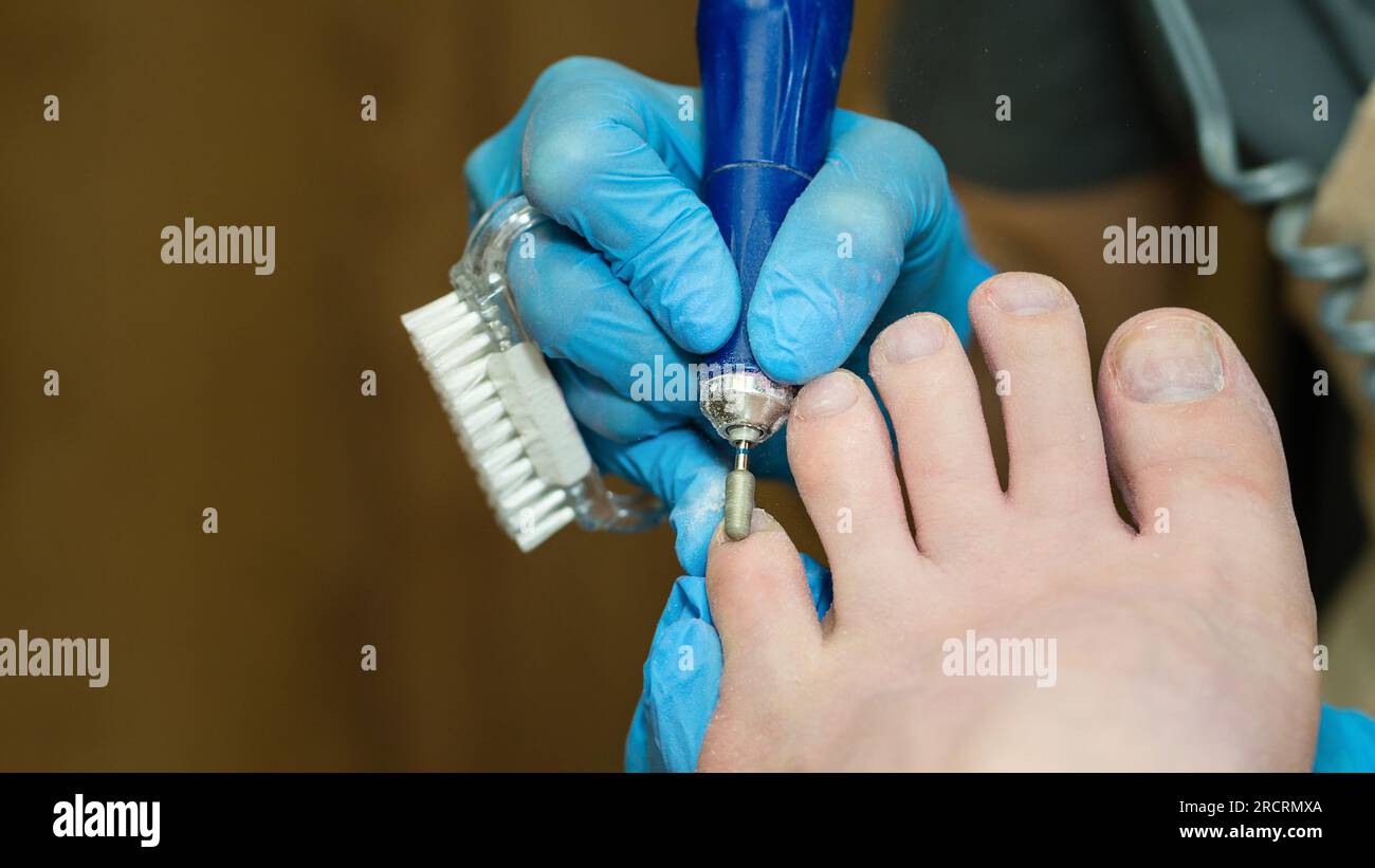 Process hardware pedicure. NAil artist polishes cuticles and ridges of ...