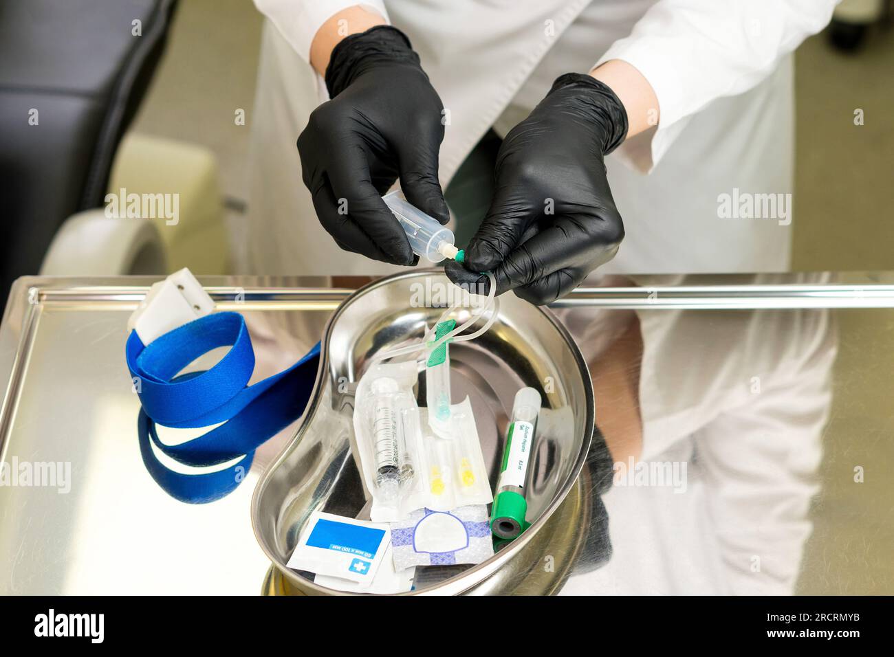 Preparing for blood test. Lab technician prepares butterfly needle with ...
