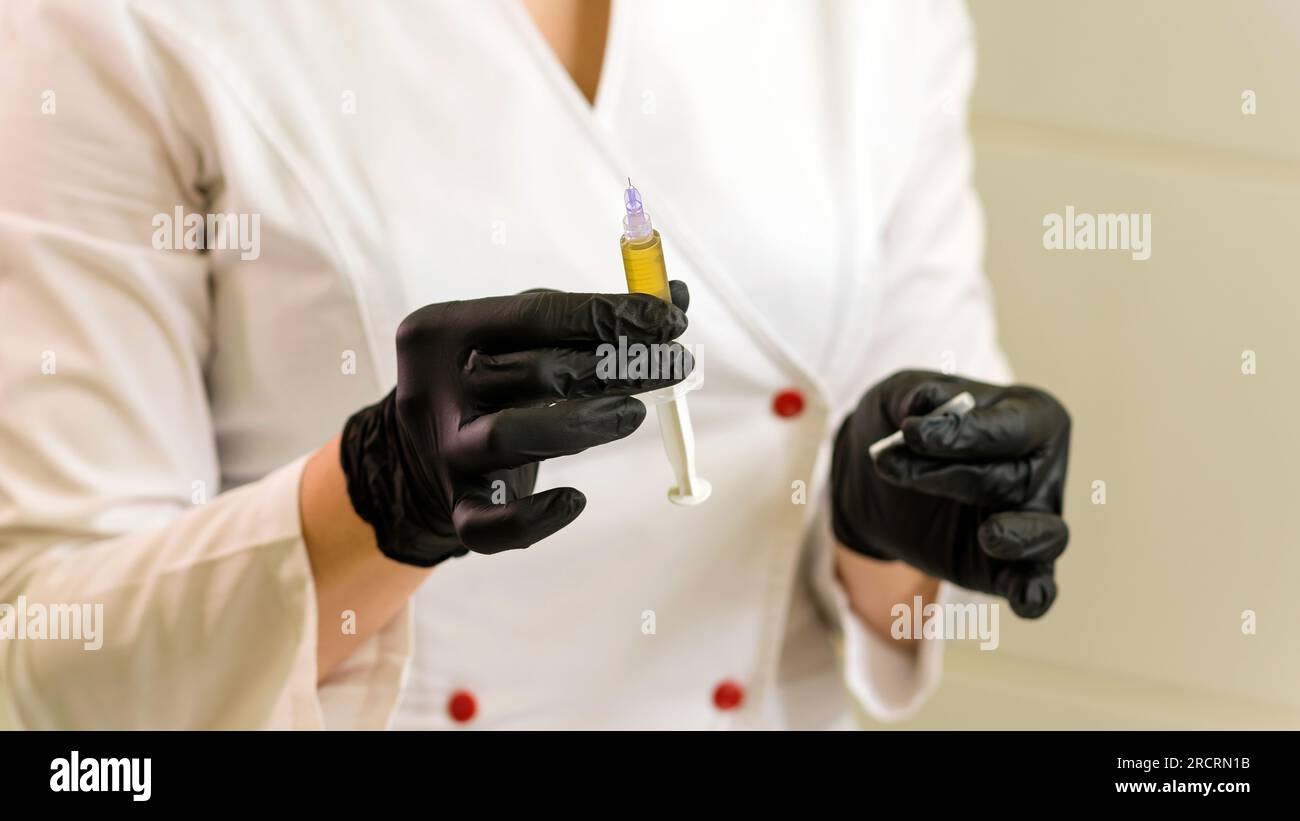 Syringe in cosmetician's hand for PRP therapy with blood platelet rich ...