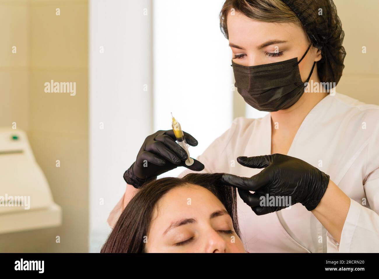 Сosmetologist uses thin needle to inject Platelet-Rich Plasma in scalp ...