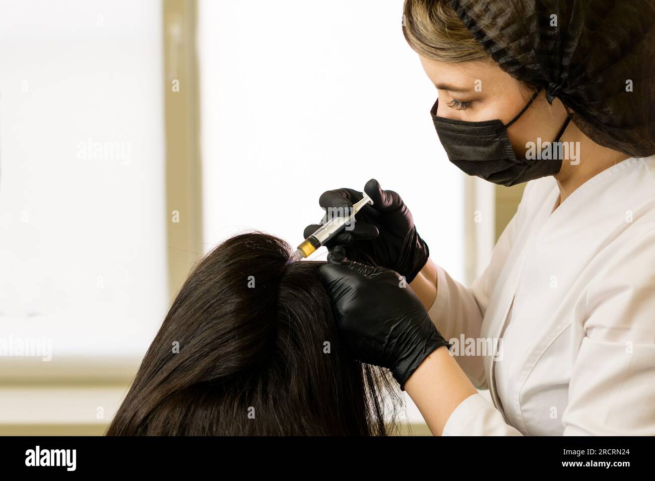 Сosmetologist uses thin needle to inject Platelet-Rich Plasma in scalp ...