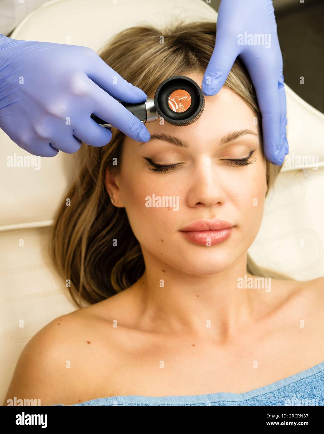 Dermatologist examines patient's birthmark with dermatoscope. Mole ...