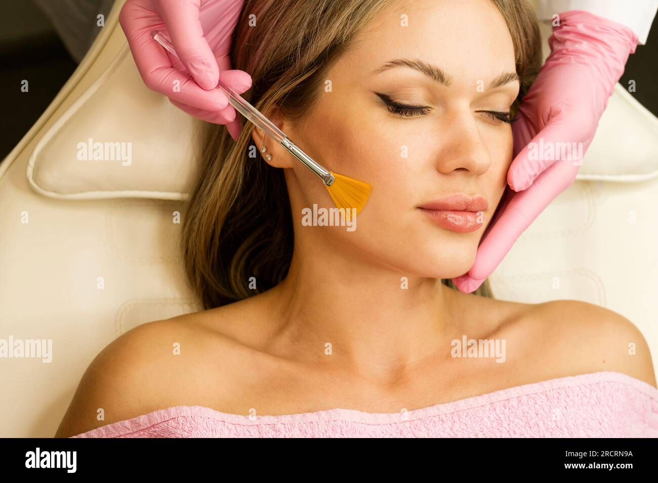 Young woman during face peeling procedure in beauty salon. Chemical ...