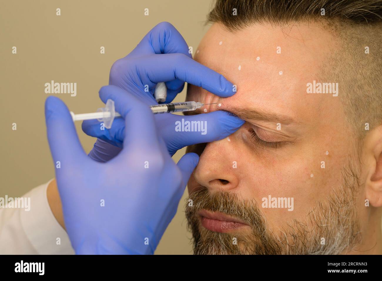 Cosmetician making botulinum toxin injections to male patient. Beauty ...