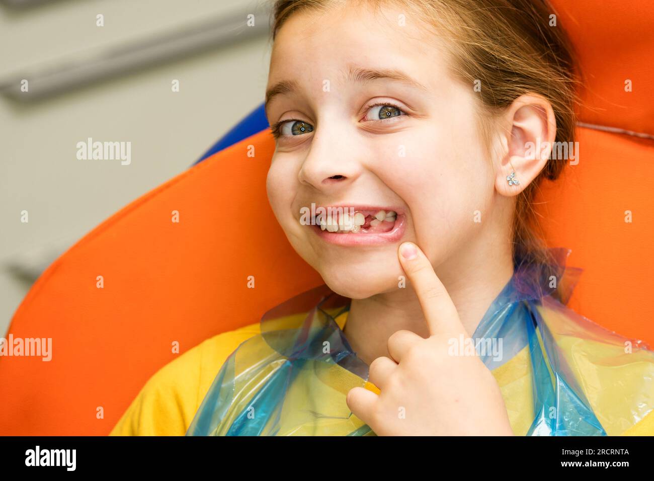 Schoolgirl showing mouth with second teeth and lost milk teeth while ...