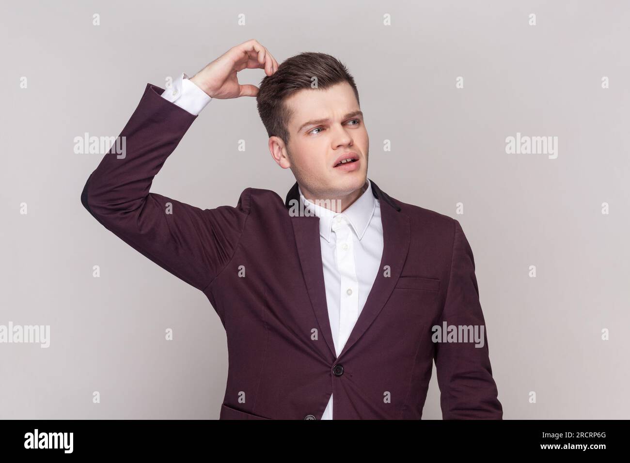 Portrait of contemplative handsome young man rubbing head as thinks ...