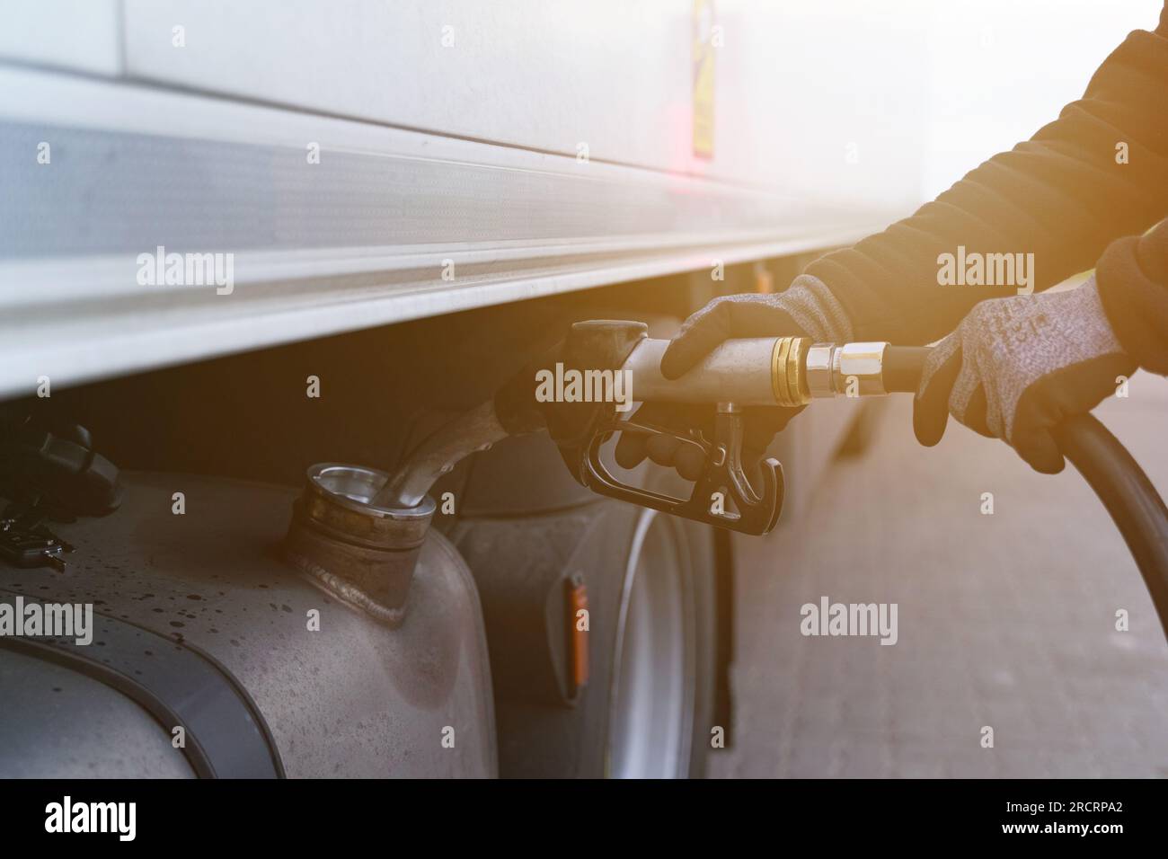 A man holds a gun in his hands, which he inserted into the neck of the ...