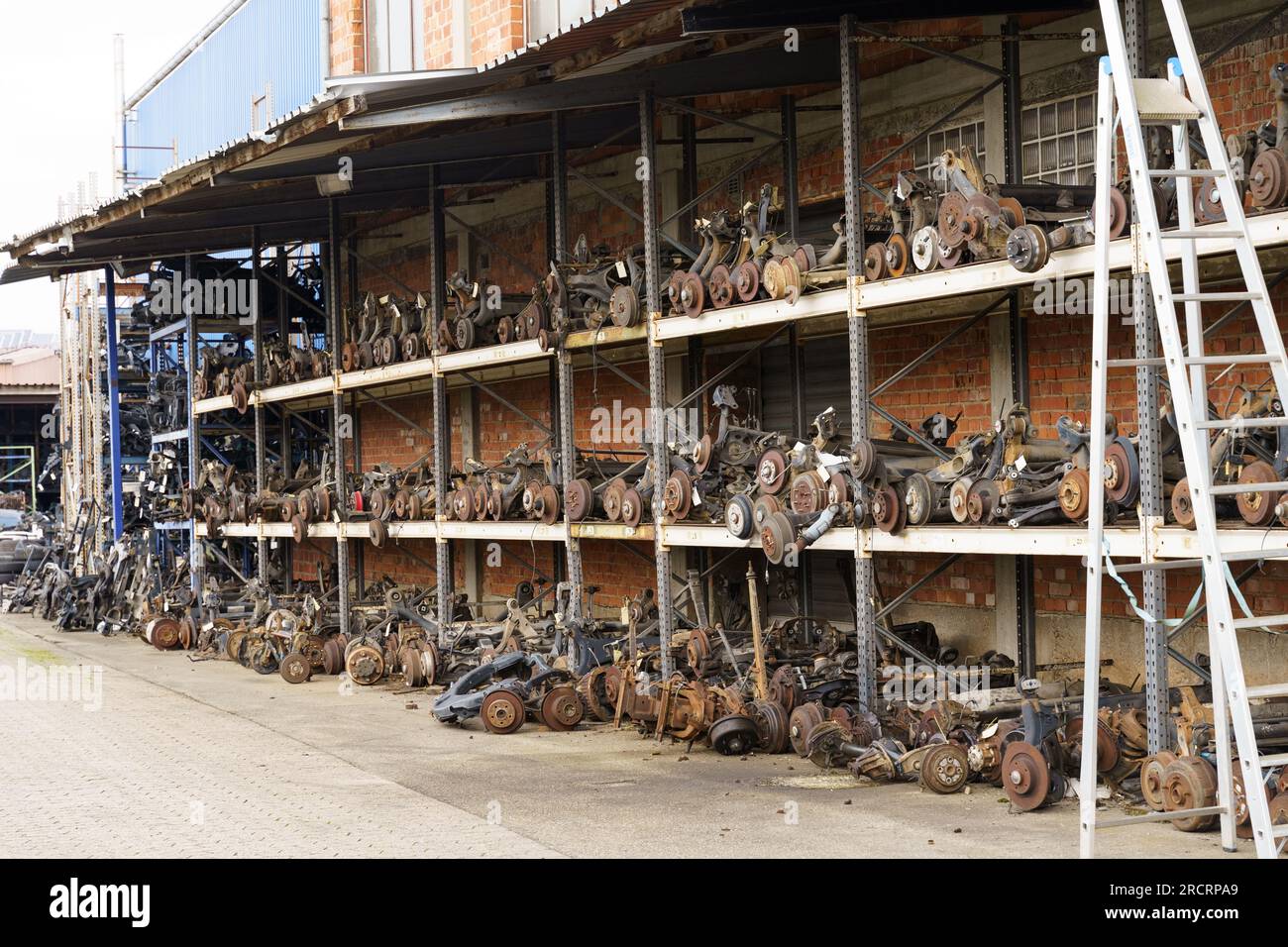 Racks with dismantled spare parts and units from cars stand under a ...