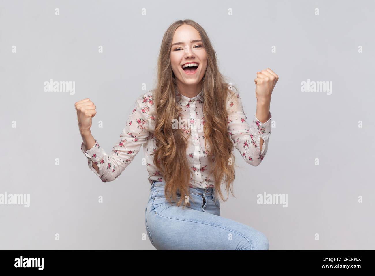 I am champion. Portrait of woman with wavy blond hair screaming for joy ...