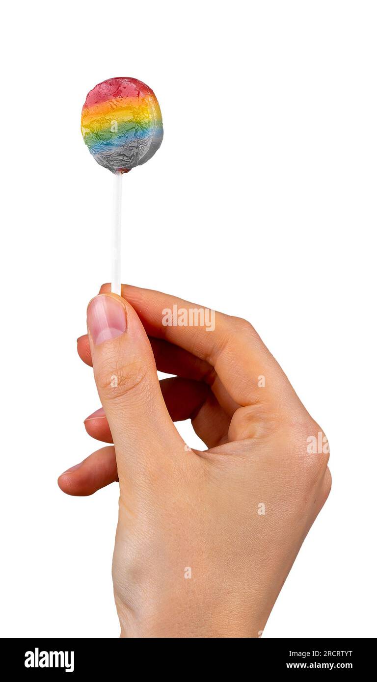 Hand holding lollipop, lolly of rainbow colors isolated on white ...