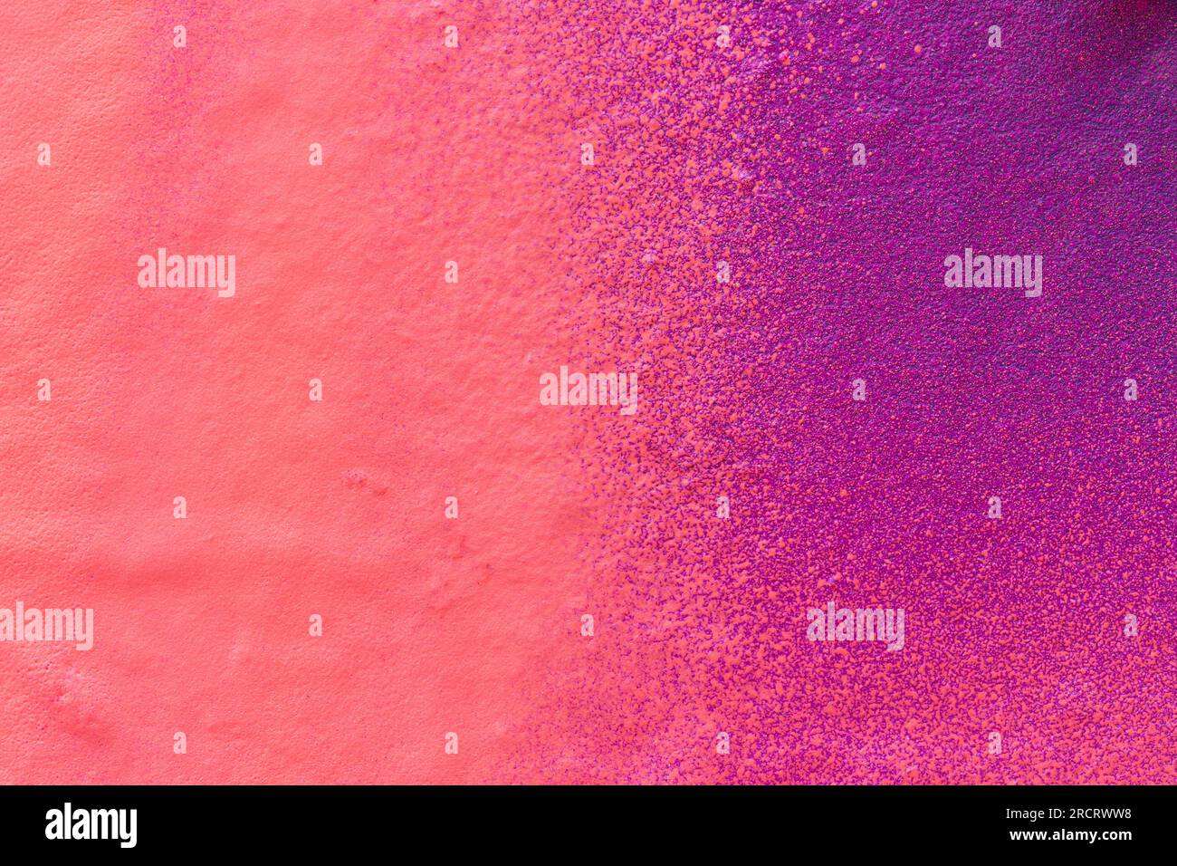 Macro close-up of a spray painted pink and purple wall with splashes ...