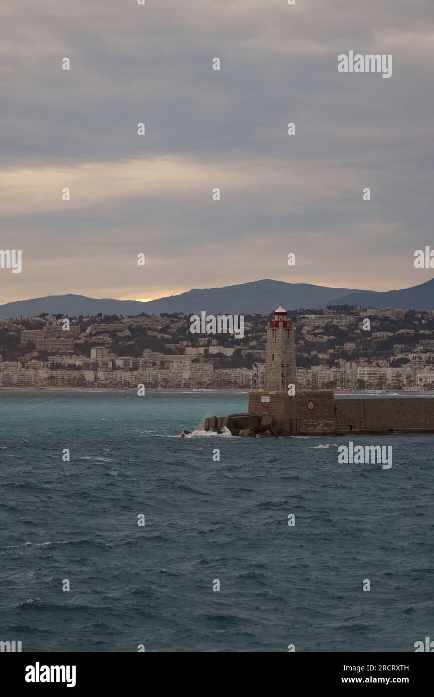 Nice port lighthouse in the harbor at sunset with uncalm sea, travel ...