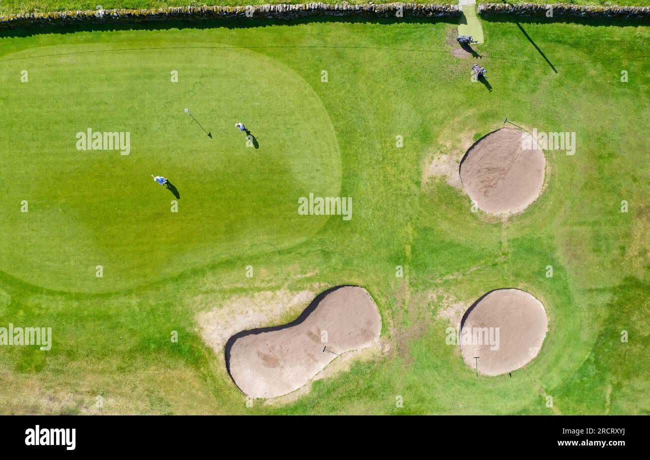 Golf course green aerial view and two players Stock Photo - Alamy