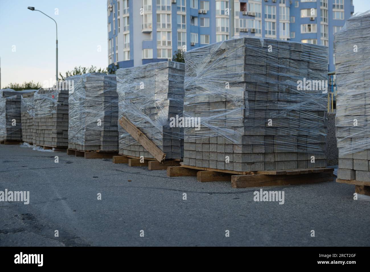 Packed paving slabs stacked on the street: piles of building materials ...