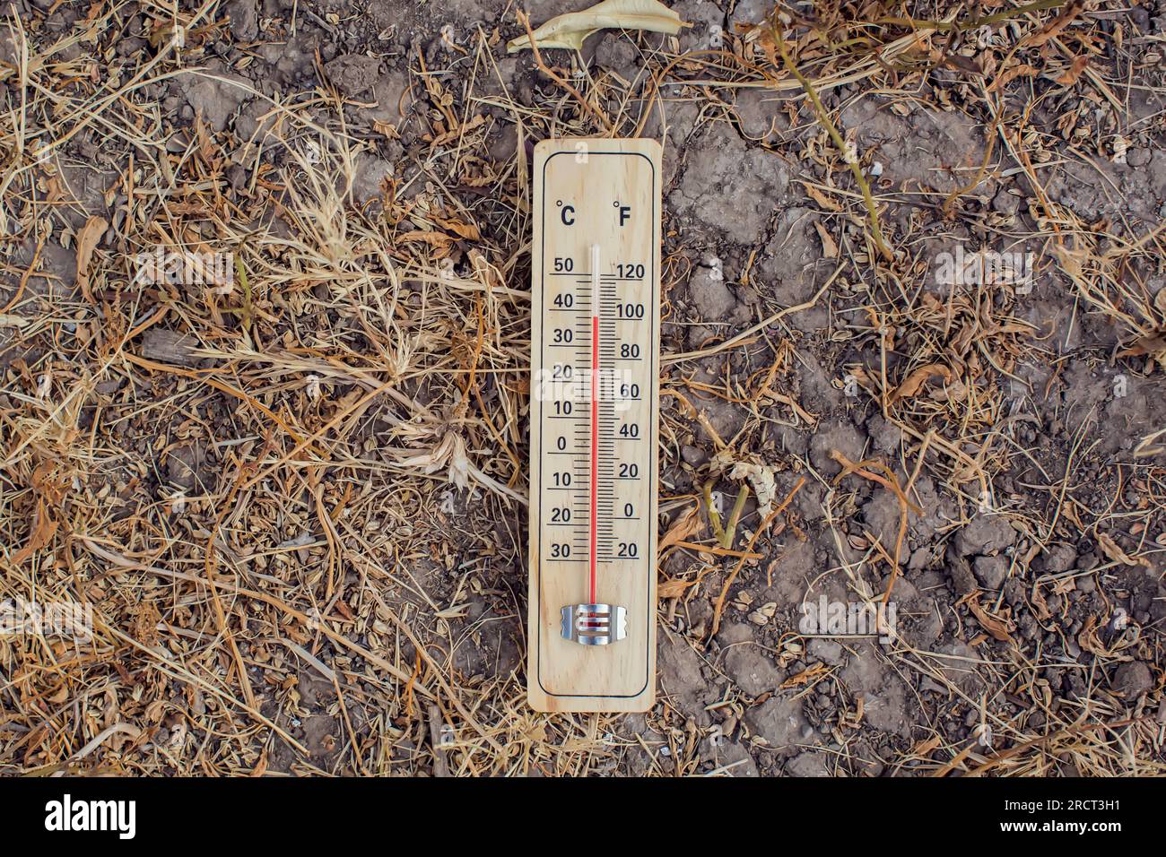 Hot weather. Thermometer in hand in front of an urban scene during ...