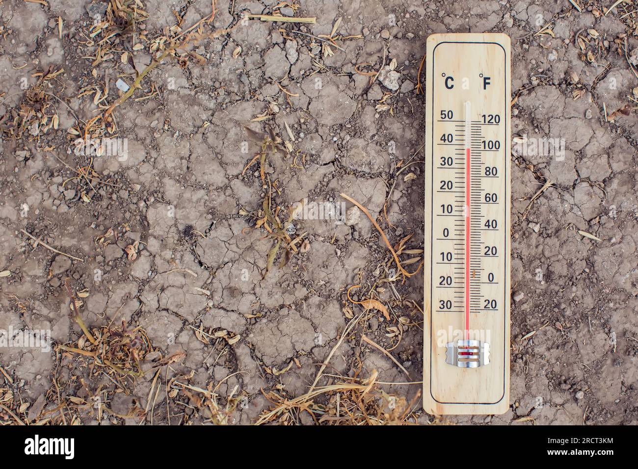 Hot weather. Thermometer in hand in front of an urban scene during ...