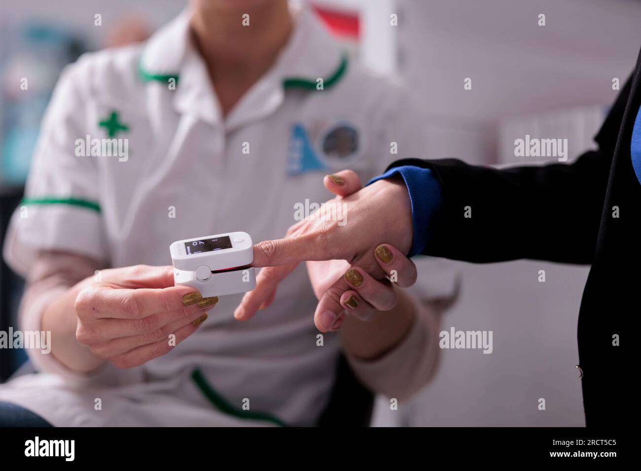 Apothecary worker putting pulse oximeter on patient finger for ...