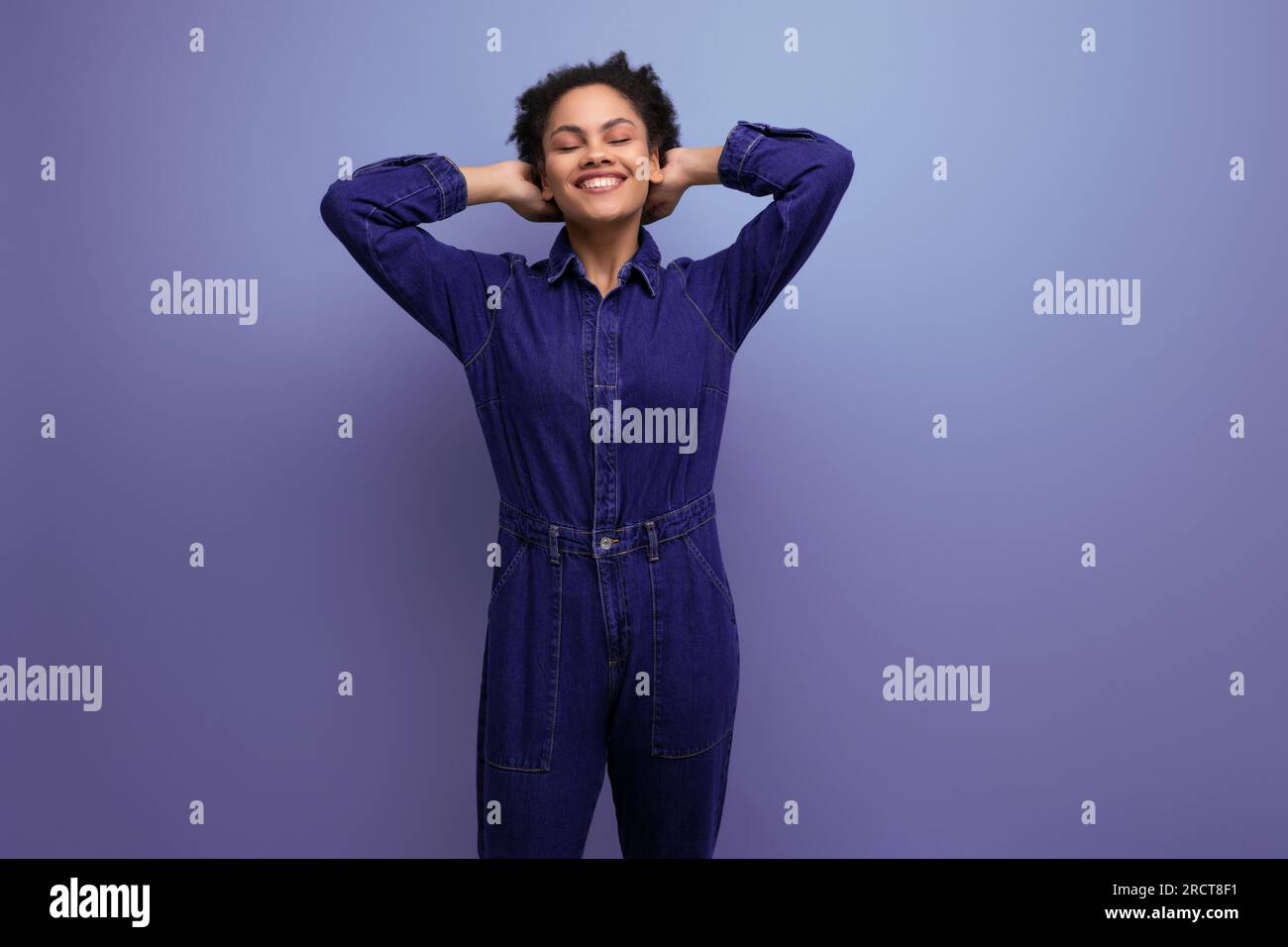 a young woman with dark skin and black hair is dressed in a blue genim ...