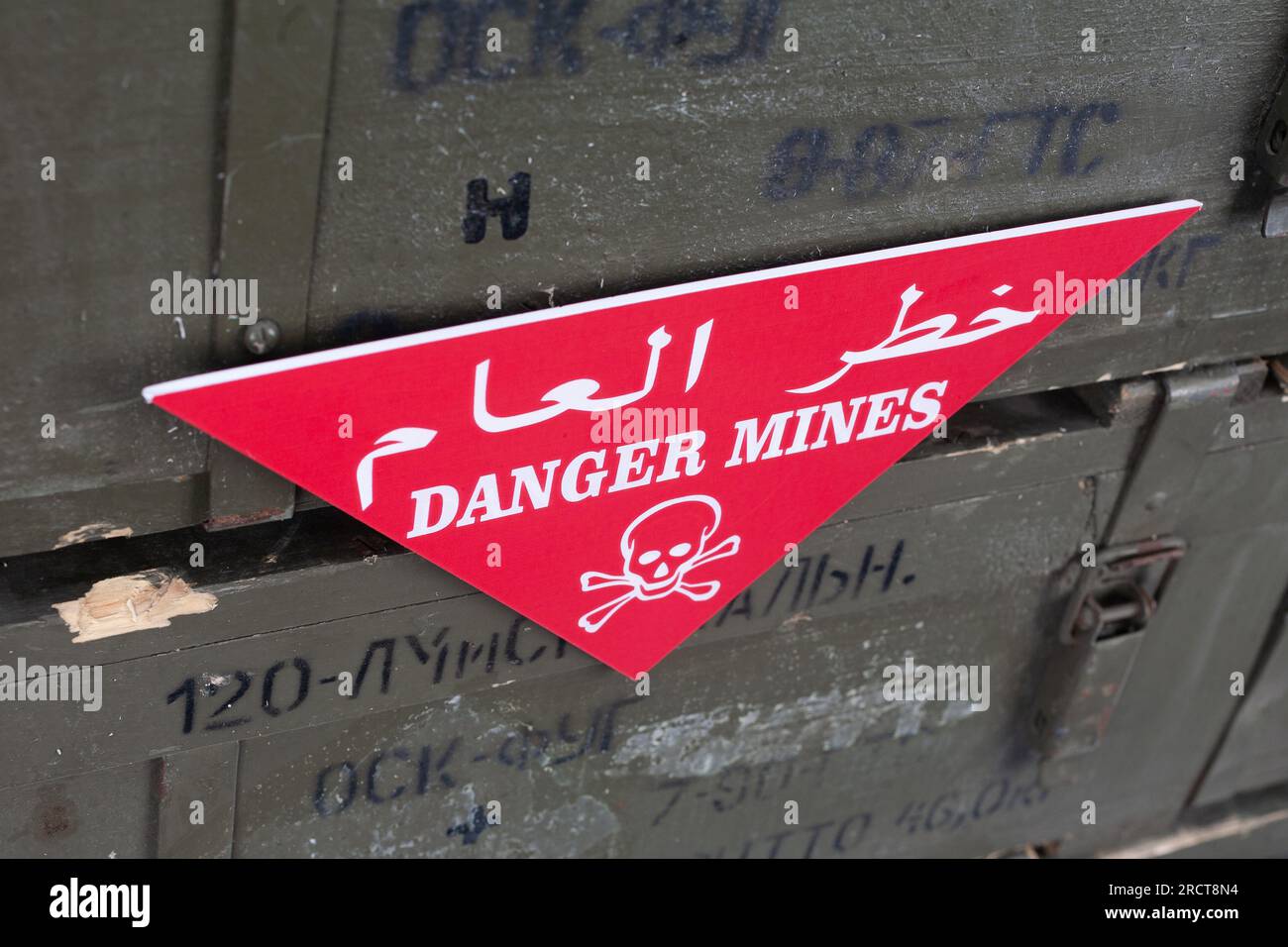 Arabic-English minefield warning red sign "Danger Mines". White skull ...