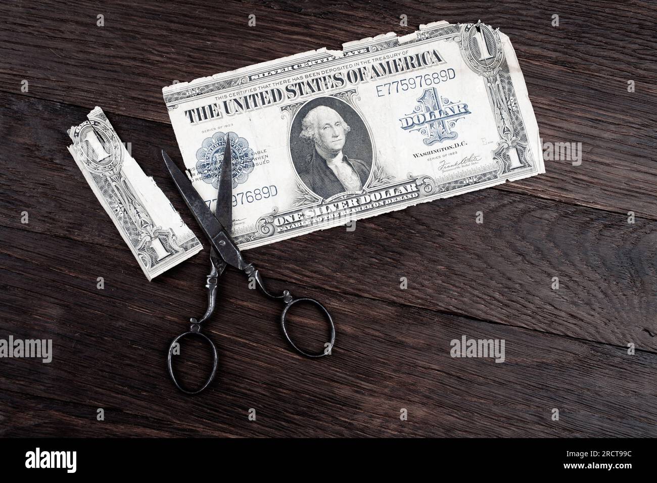 Vintage embroidery scissors cutting old paper dollar bill on wooden ...