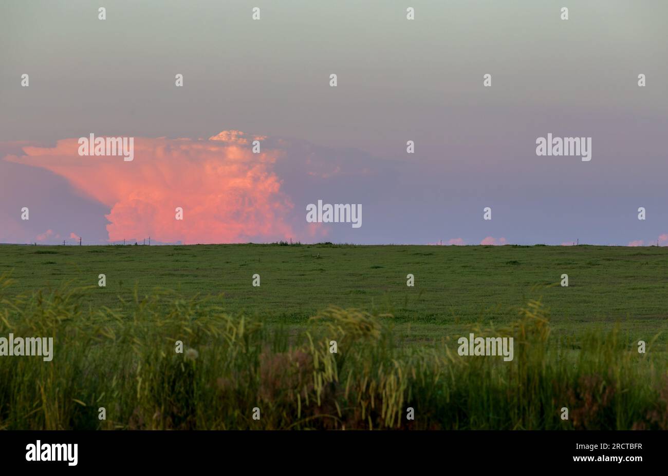 Sunset skies in summer over the prairie and suburban neighborhood in ...