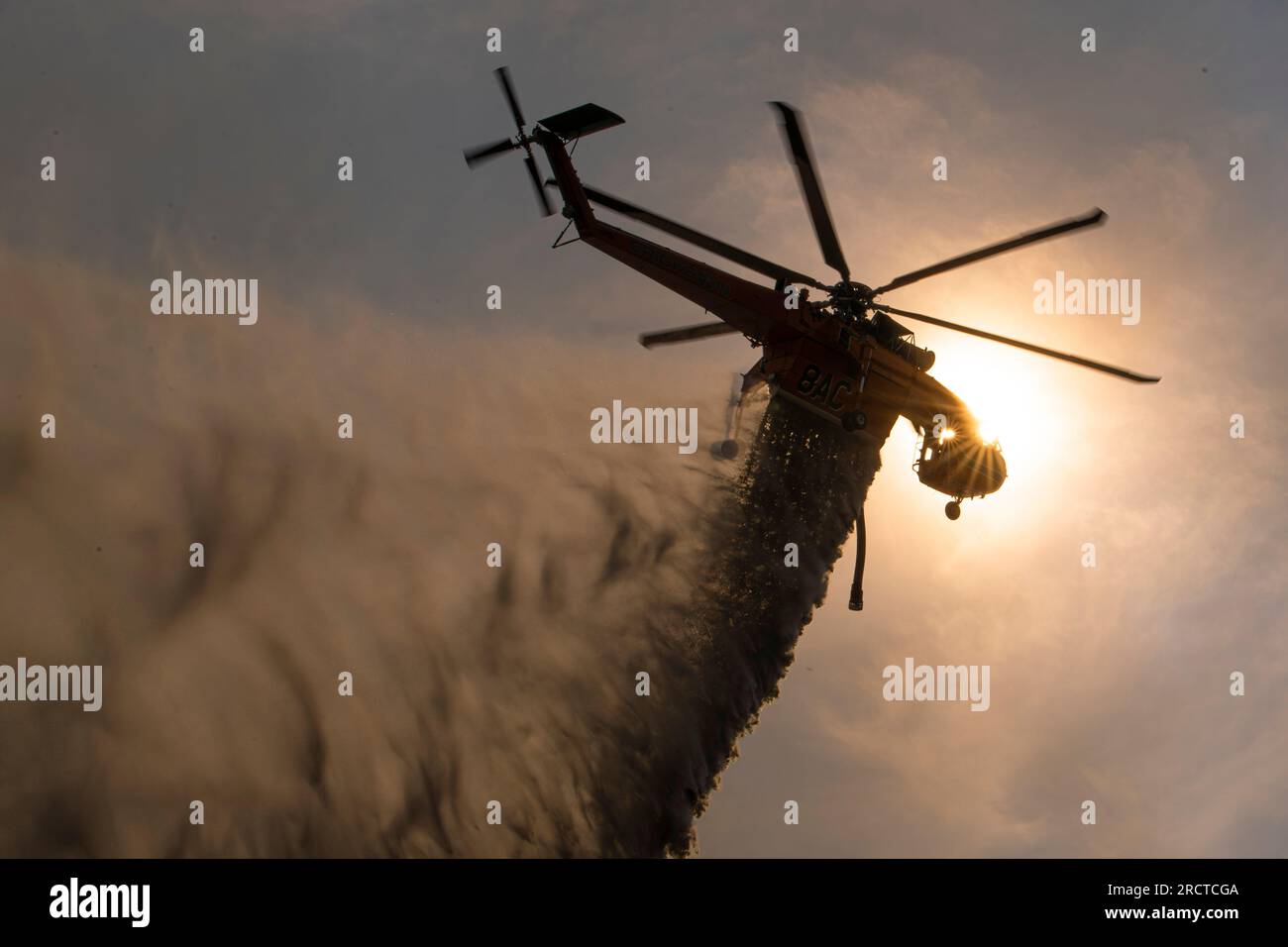 A CalFire Heli-tanker makes a water drop over the Rabbit fire flames ...
