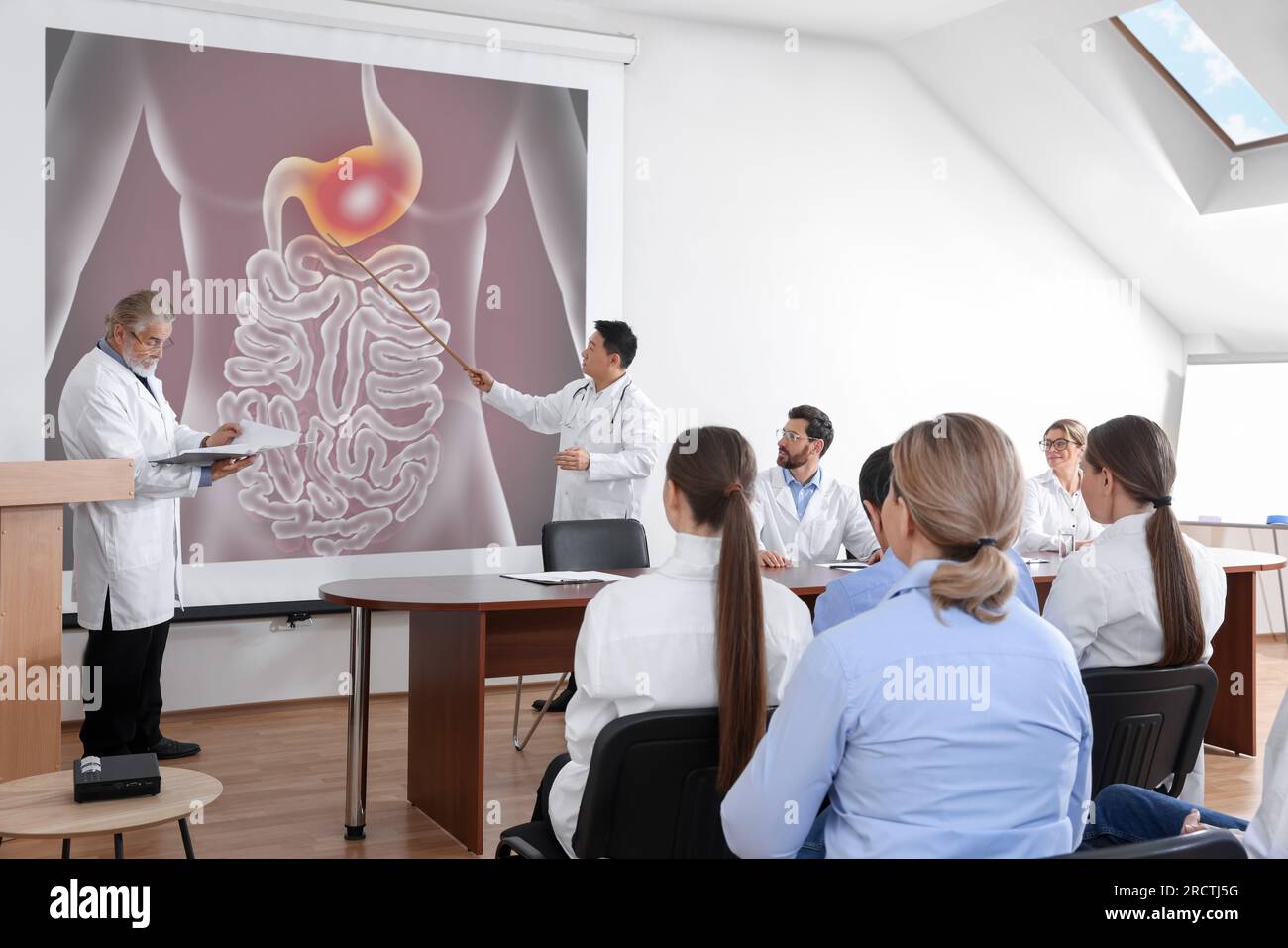 Lecture in gastroenterology. Conference room full of professors and doctors. Projection screen ...