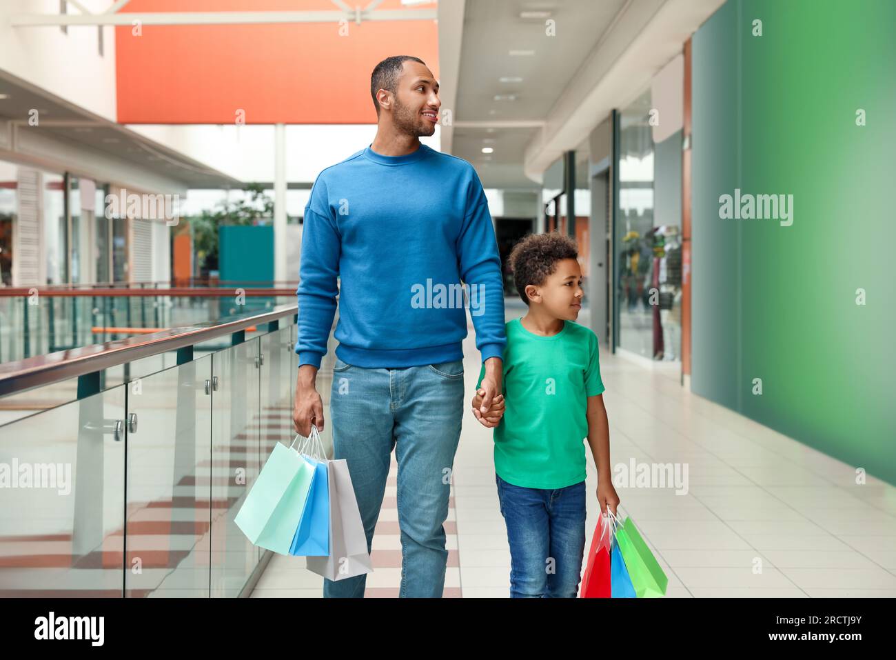 Family shopping. Happy father and son with colorful bags in mall Stock ...