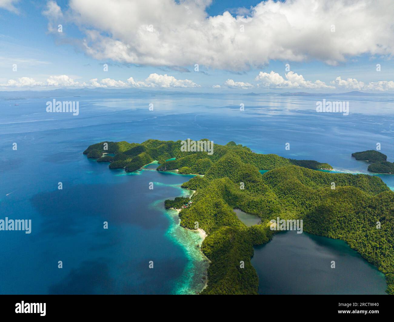 Tropical Island with white sand beach surrounded by deep blue sea and ...