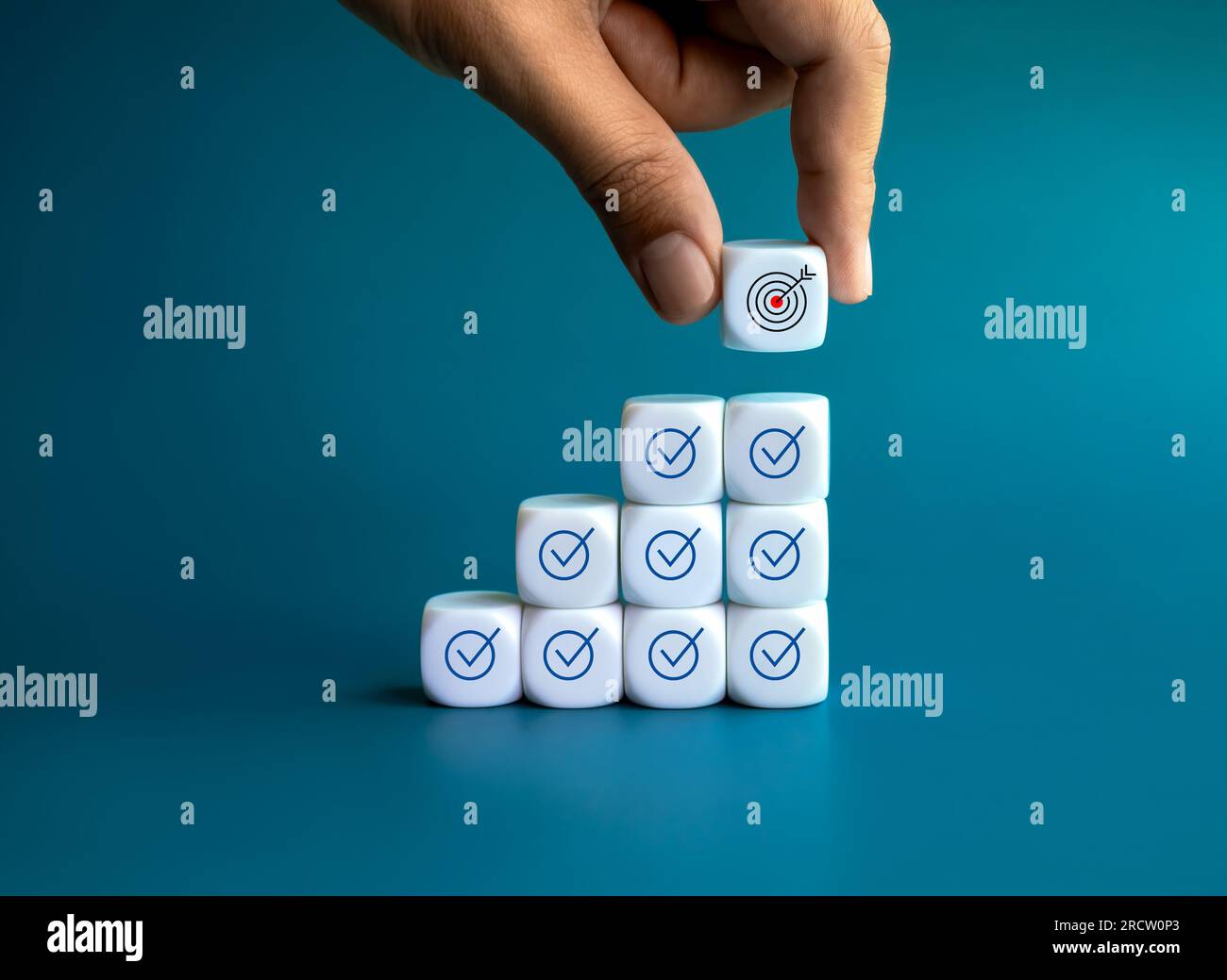 Business goal and success. Target icon on white block put by hand on ...