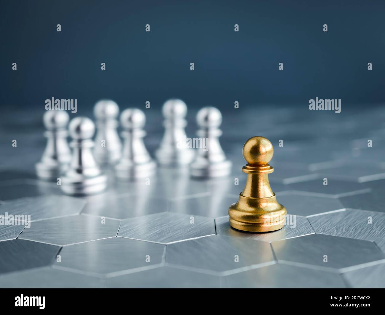 The golden pawn chess piece standing out from the group of silver pawn ...