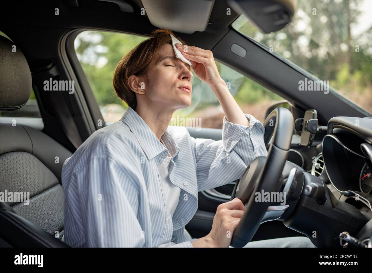 Woman drives car with broken air conditioning in hot summer weather ...
