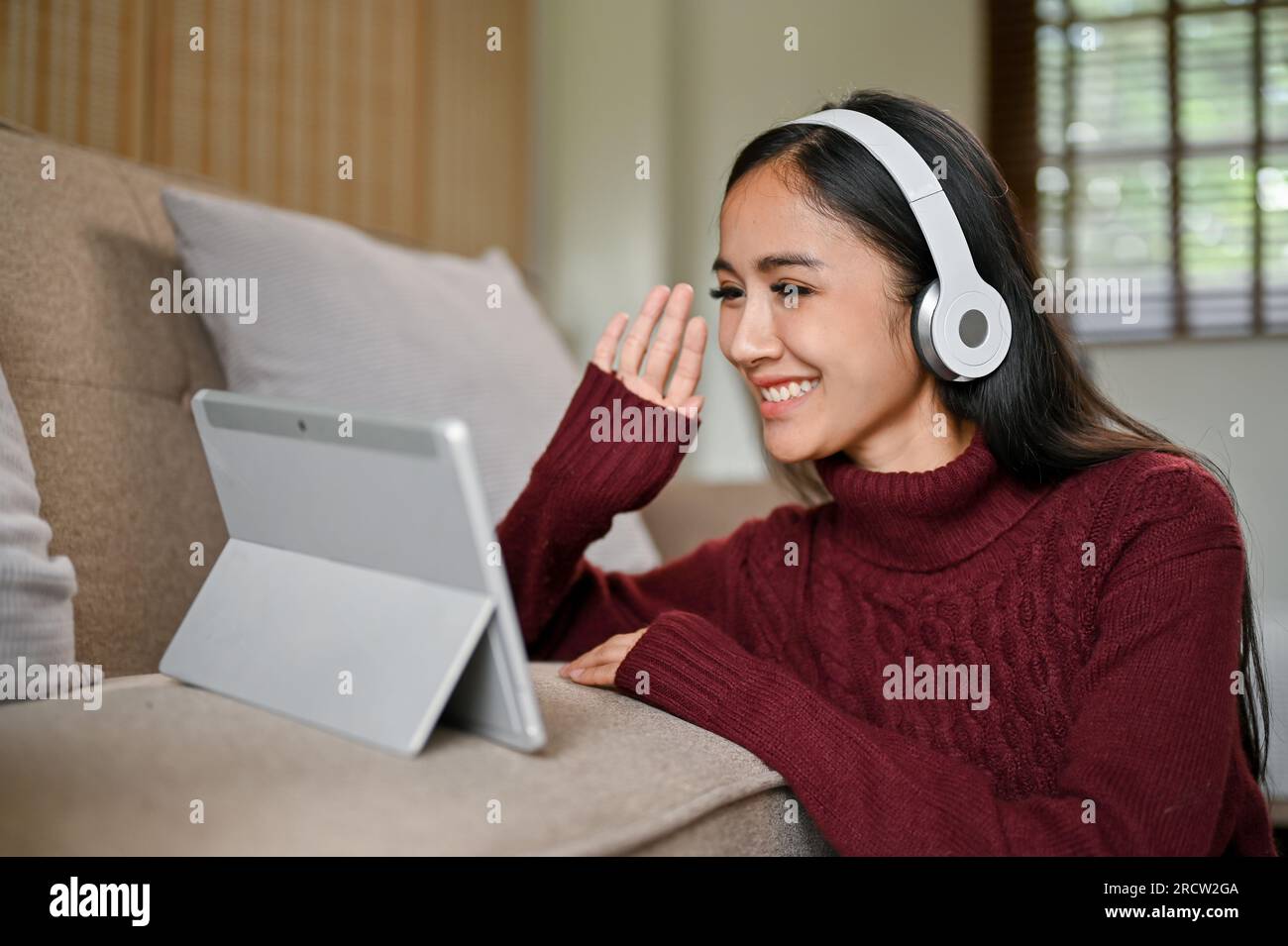 Close-up image of a beautiful Asian woman in a cosy sweater wearing ...
