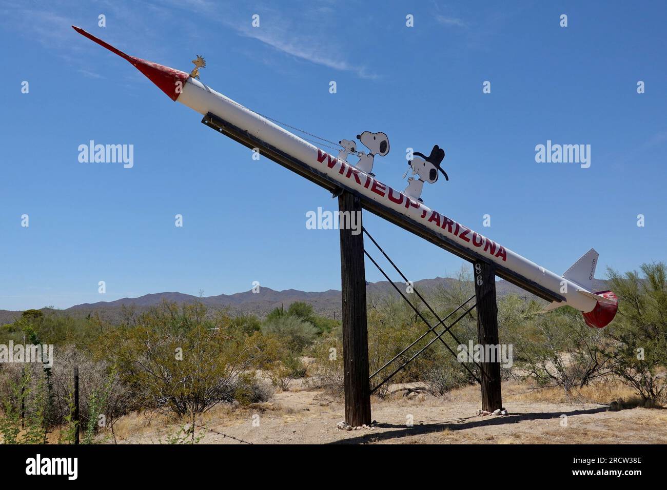 A roadway sign for the town of Wikieup, Arizona of a rocket with Snoopy ...