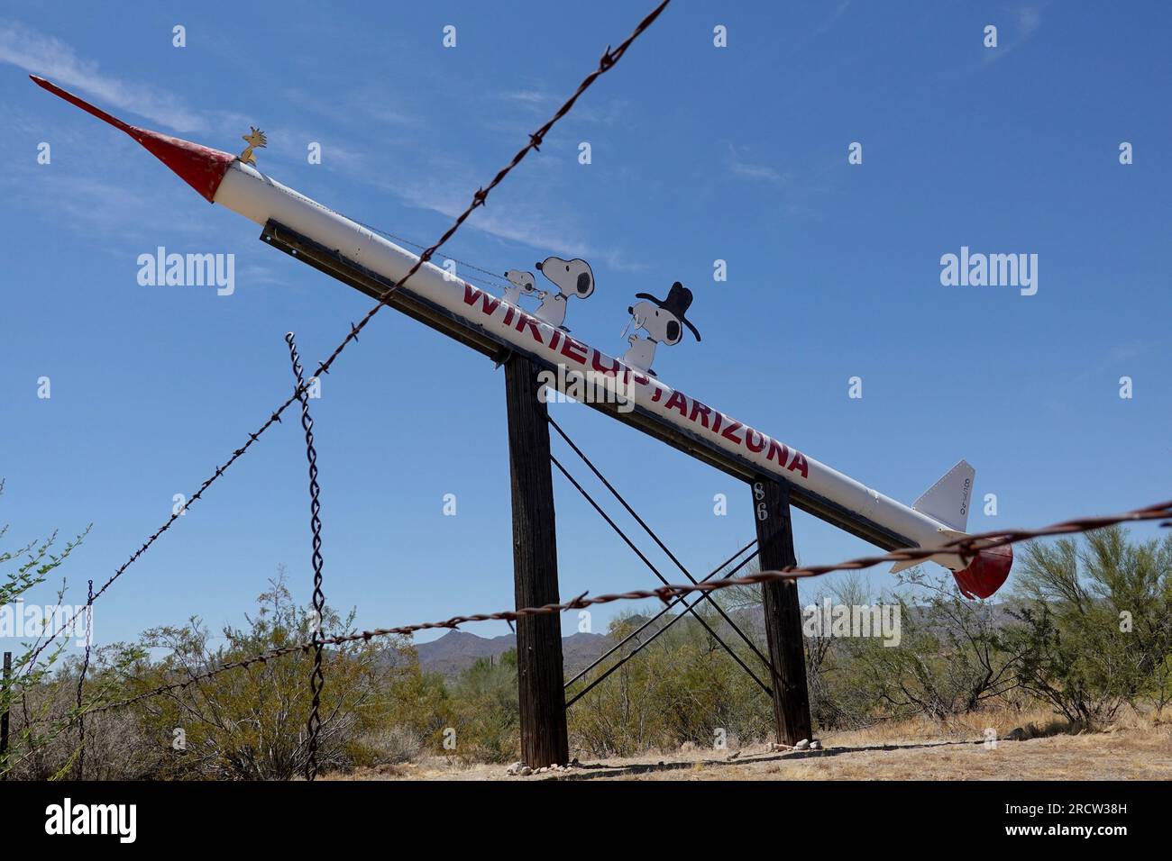 A roadway sign for the town of Wikieup, Arizona of a rocket with Snoopy ...