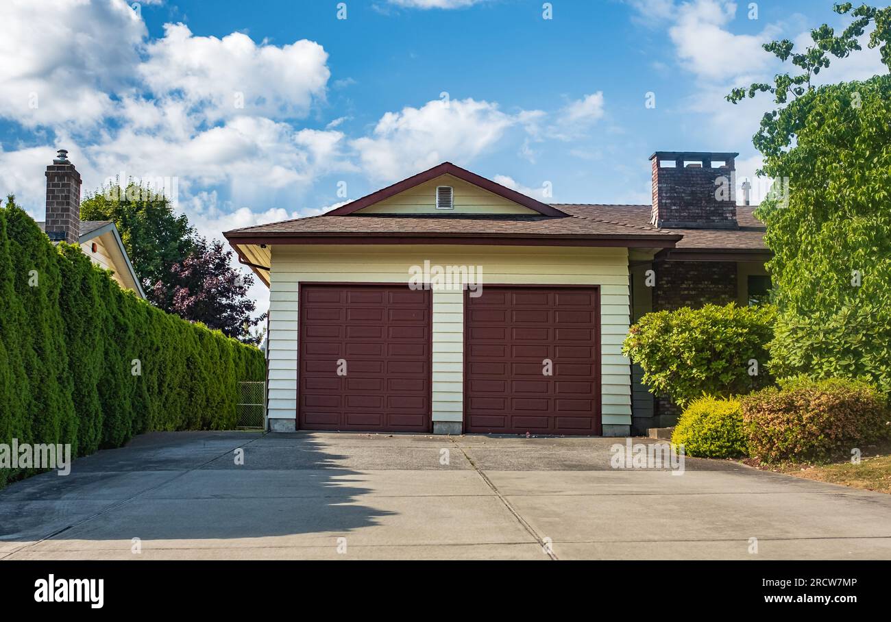 Double garage with short driveway in a sunny summer day. A perfect ...