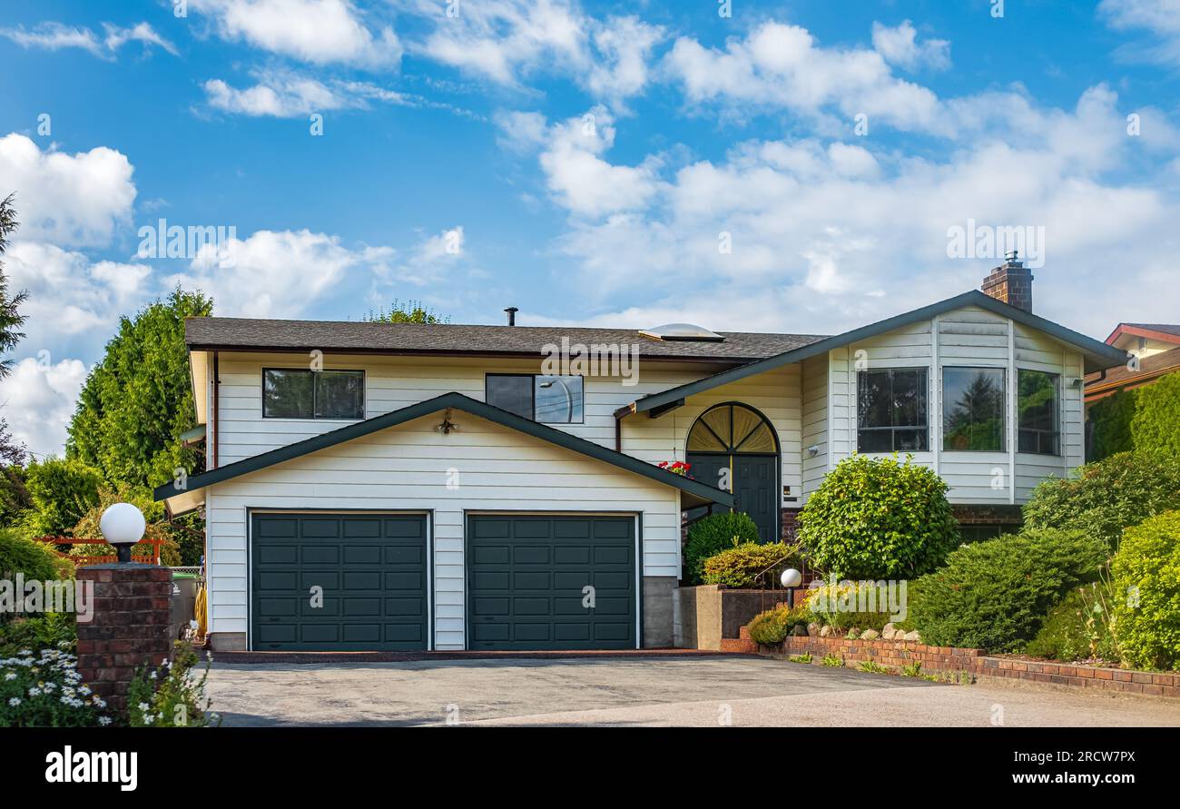 Double garage with short driveway in a sunny summer day. A perfect ...