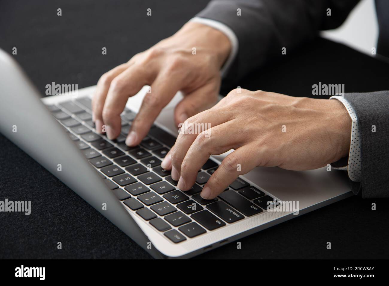 Closeup of businessman's hands typing on a laptop computer for data ...