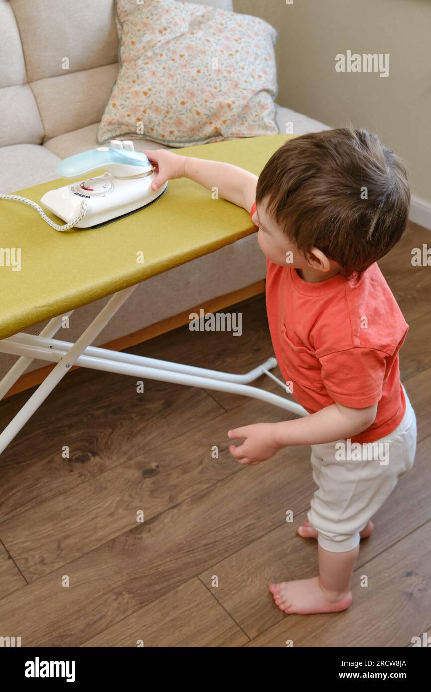 Child's safety is at risk as the baby recklessly plays with the hot ...