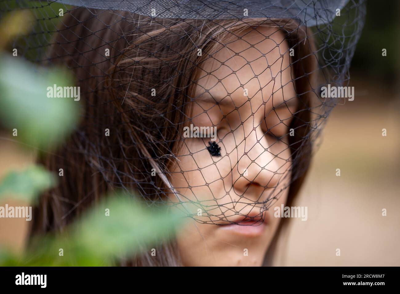Close-up of a grieving young woman wearing a mourning veil (symbol ...