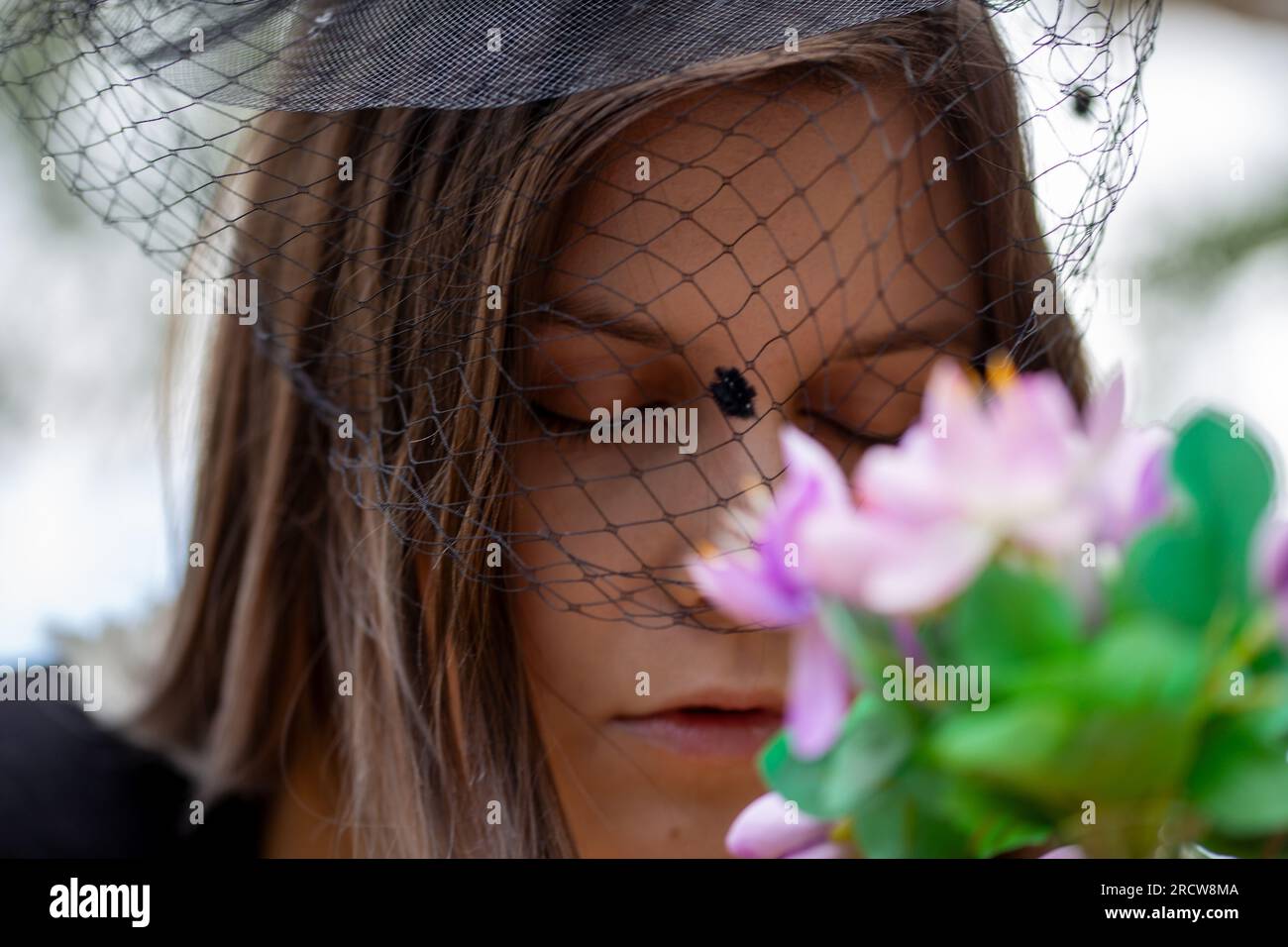 Close-up of a grieving young woman wearing a mourning veil (symbol ...