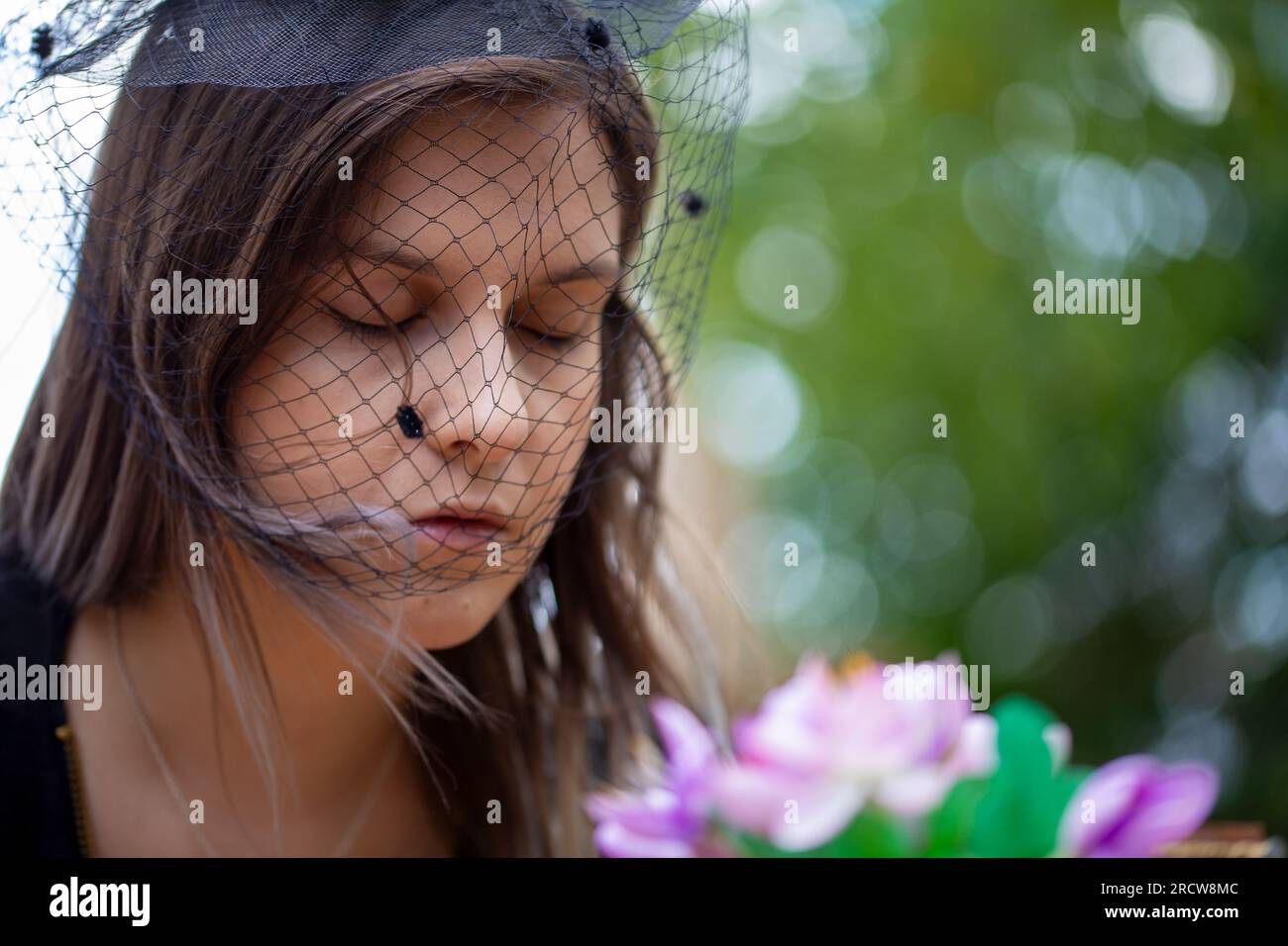 Close-up of a grieving young woman wearing a mourning veil (symbol ...