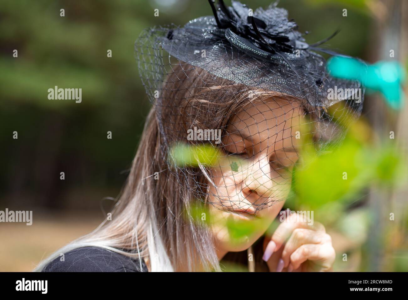 Close-up of a grieving young woman wearing a mourning veil (symbol ...