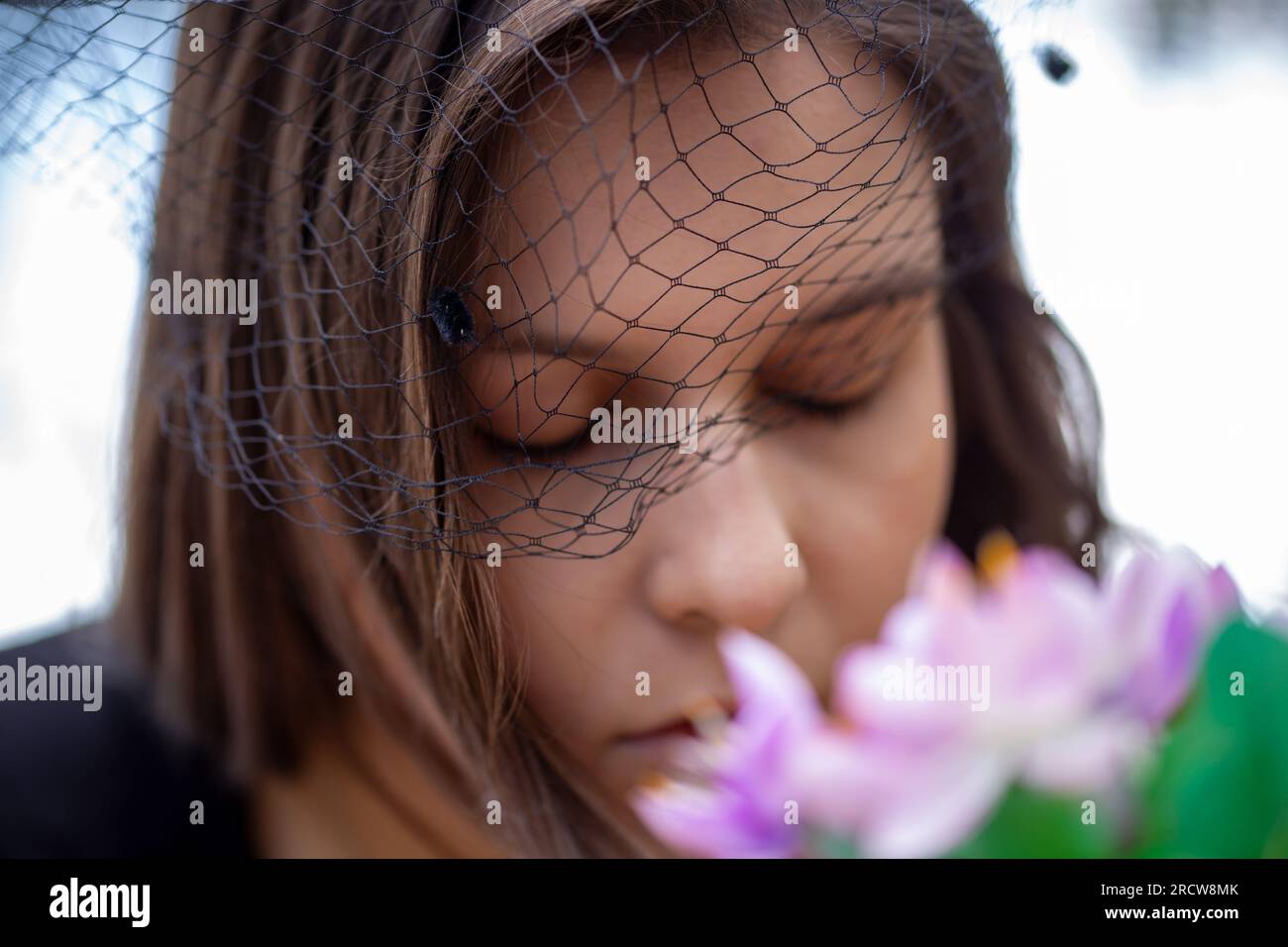 Close-up of a grieving young woman wearing a mourning veil (symbol ...