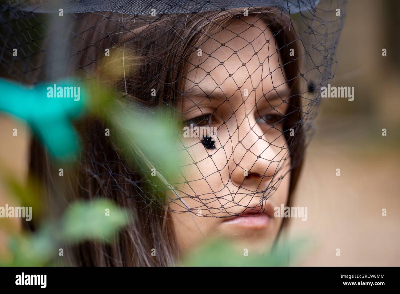 Close-up of a grieving young woman wearing a mourning veil (symbol ...