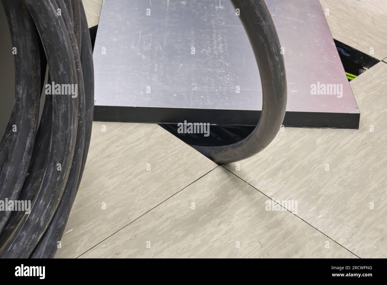 The flooring installation team carefully lays out the wires and cables ...