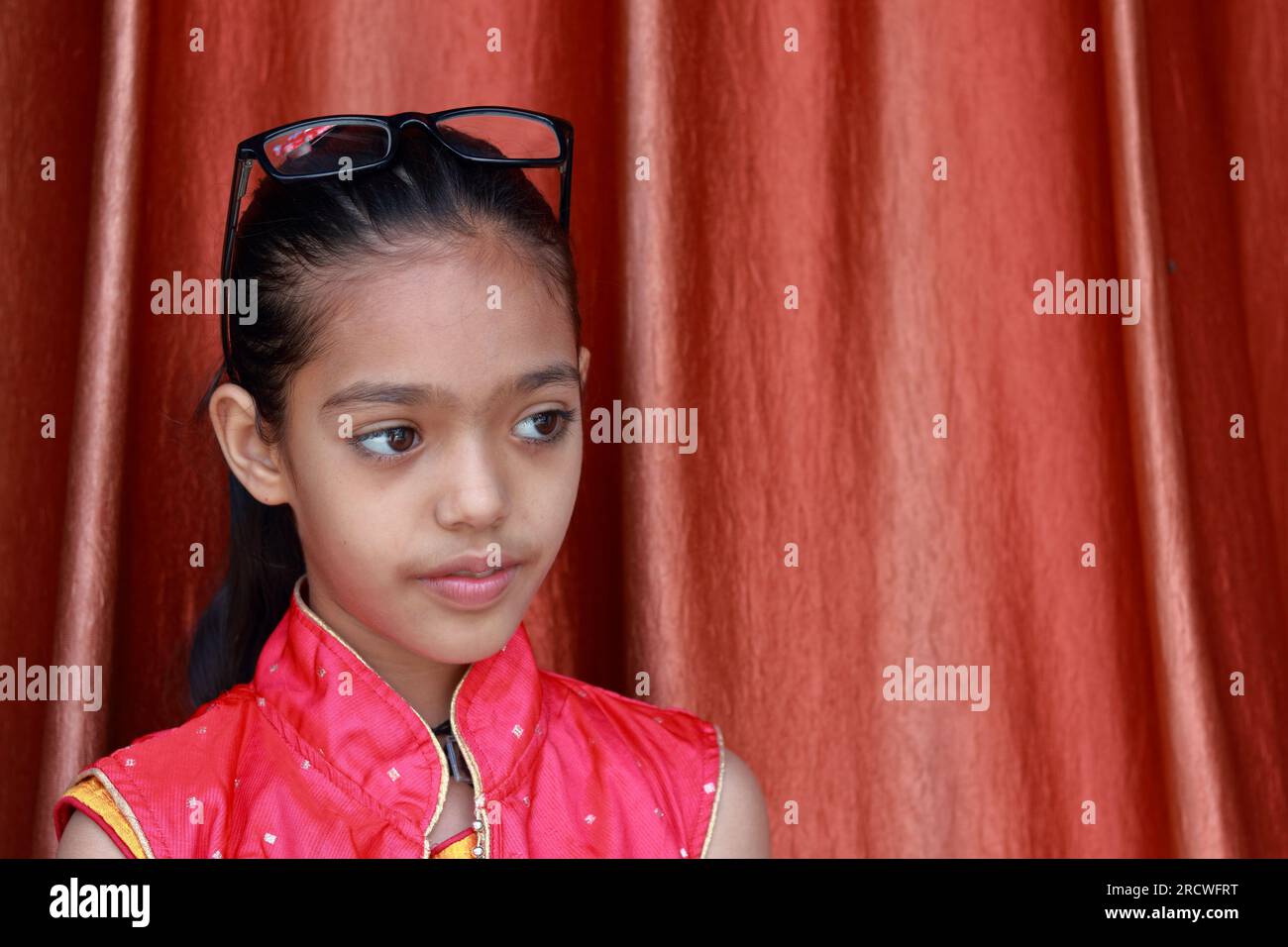 An Indian little pretty girl fiddling with her eye glasses in various ...