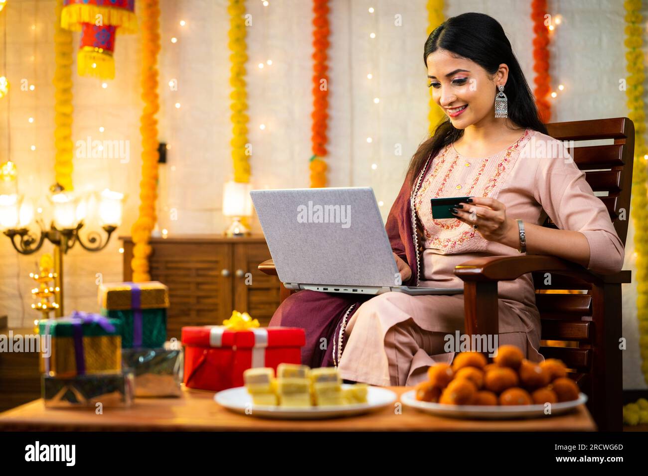 Happy young indian girl making online shopping on laptop using credit ...