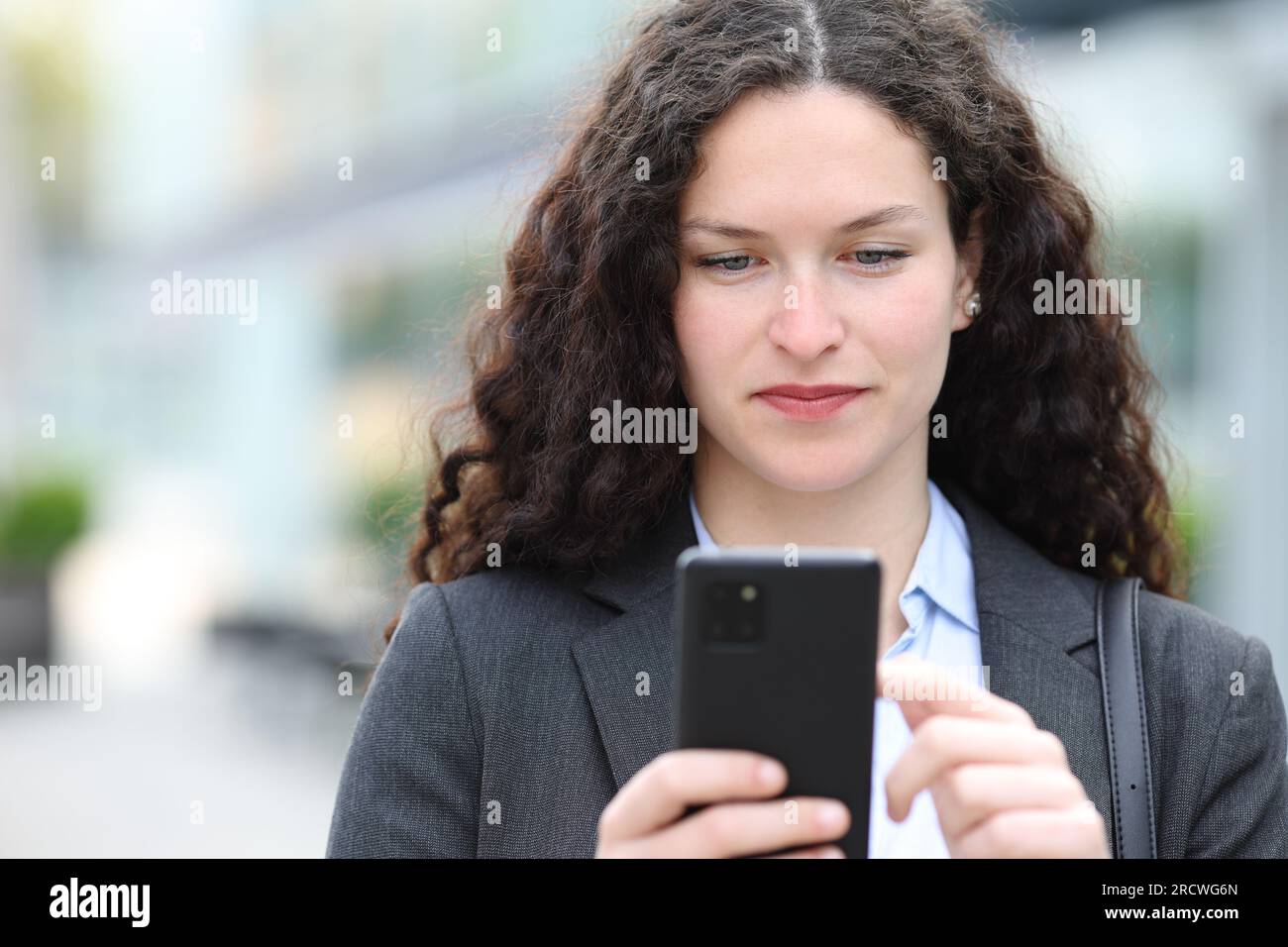 Front view portrait of an executive using phone in the street Stock ...