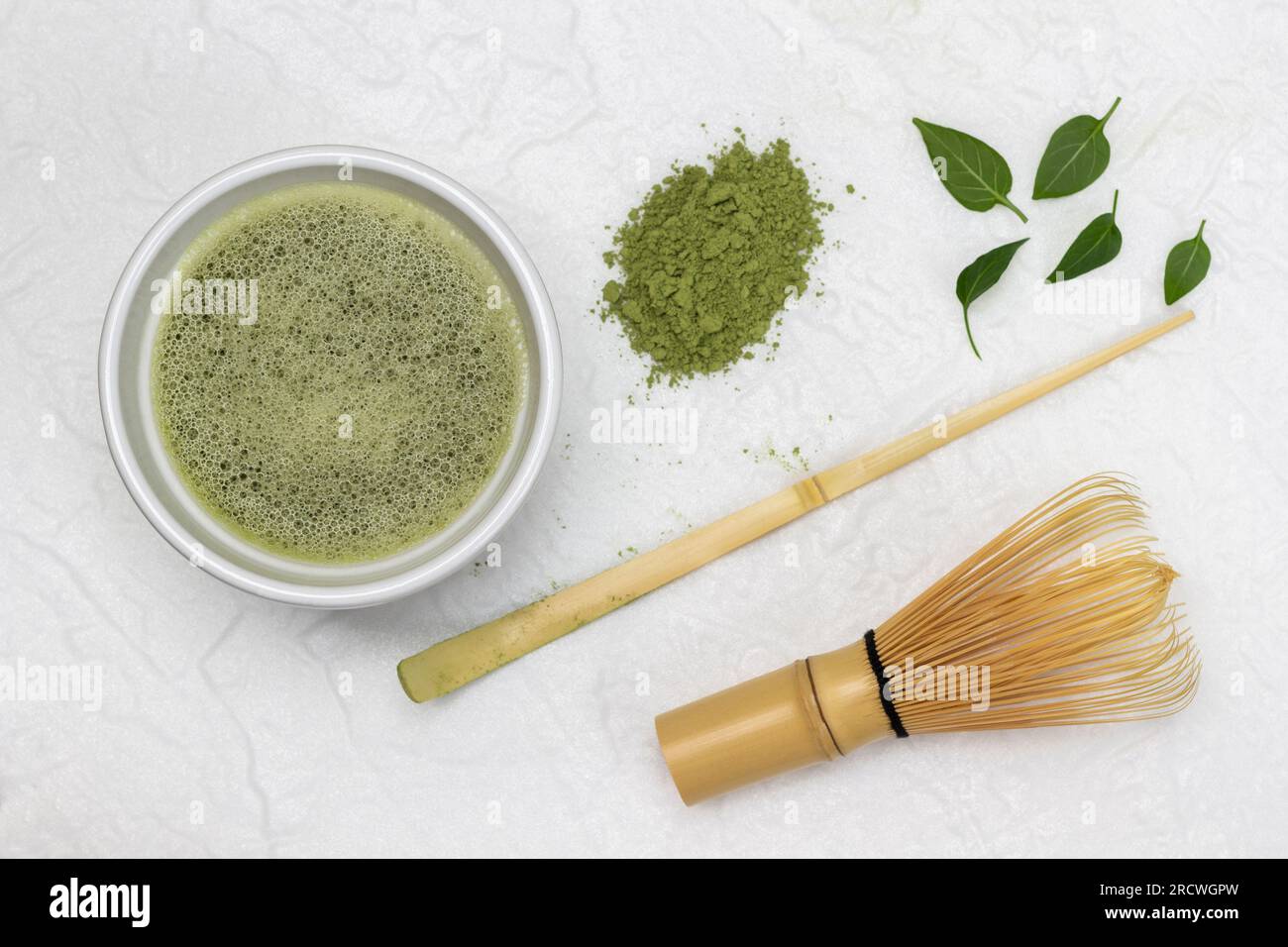 Matcha tea in a bowl. Matcha green tea powder, bamboo whisk and ...